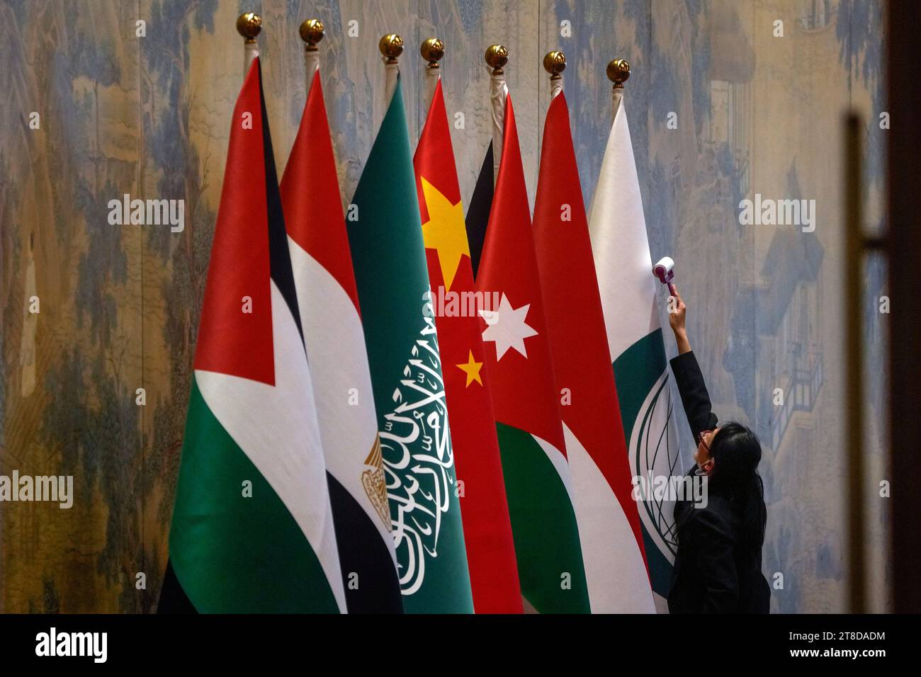 A staff member wipes on national flags from left, Palestinians, Egypt ...