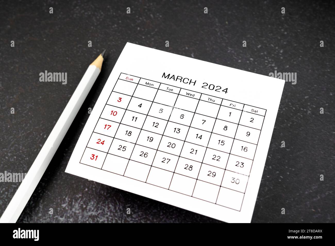 White calendar page for March 2024 and pencil on black background Stock ...