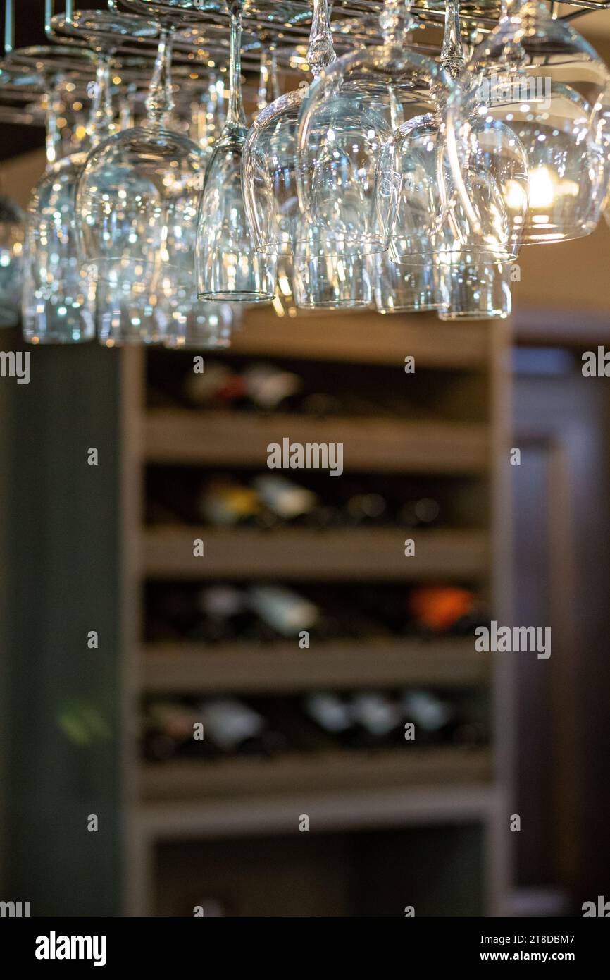 Clean wine glasses hanging over the bar counter on out of focus ...