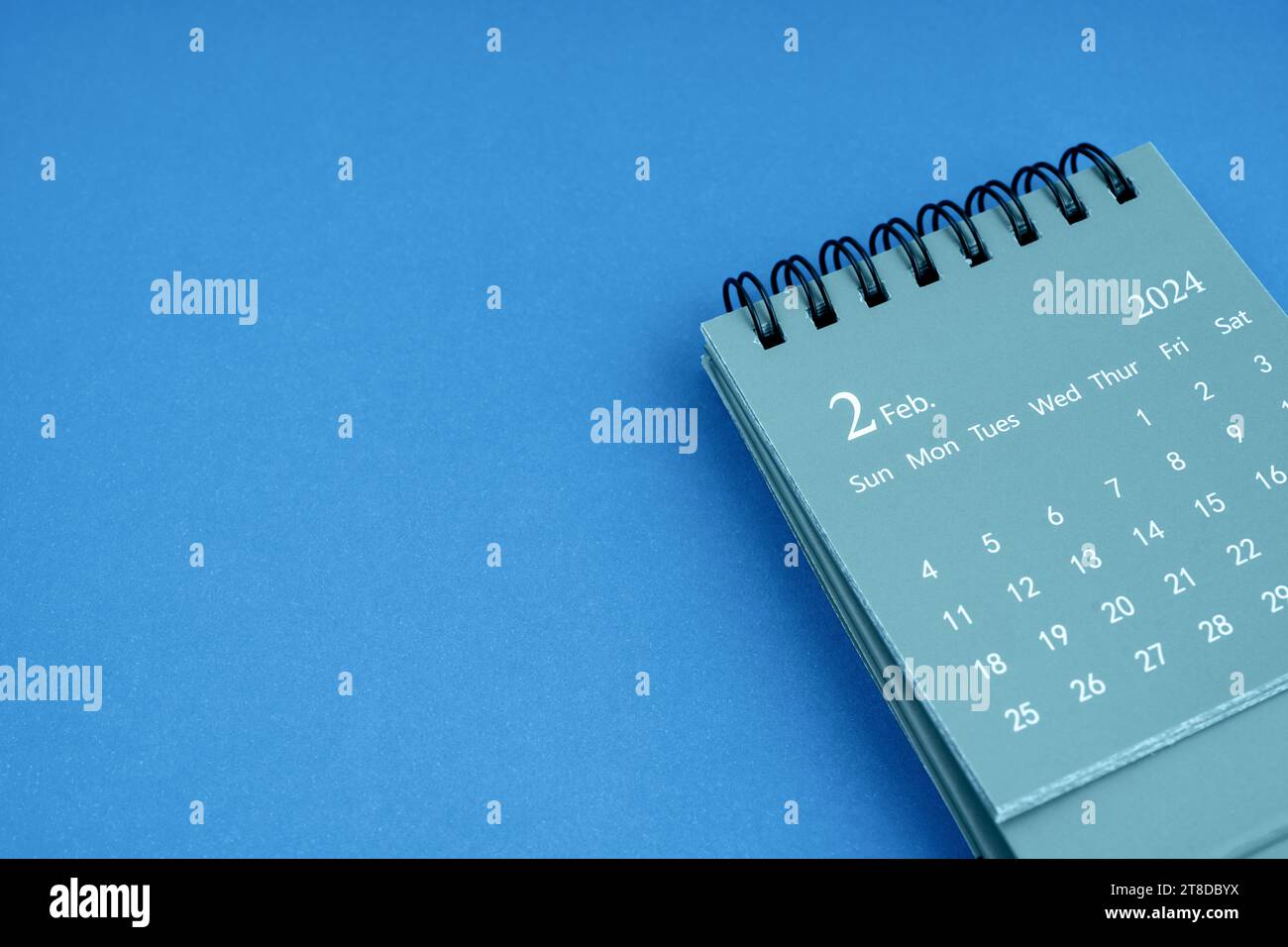 February 2024 desk calendar on blue color background. Copy space Stock ...