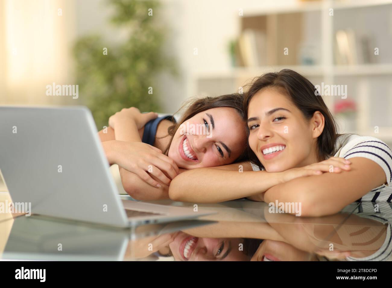 Happy roommates with laptop looking at you at home Stock Photo - Alamy
