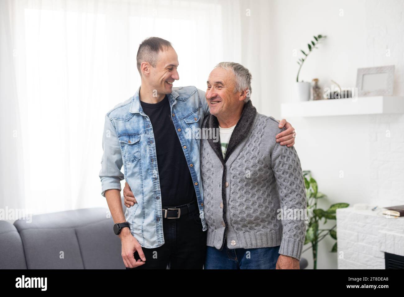 Portrait of happy smiling father and his adult son. Man hugging his ...