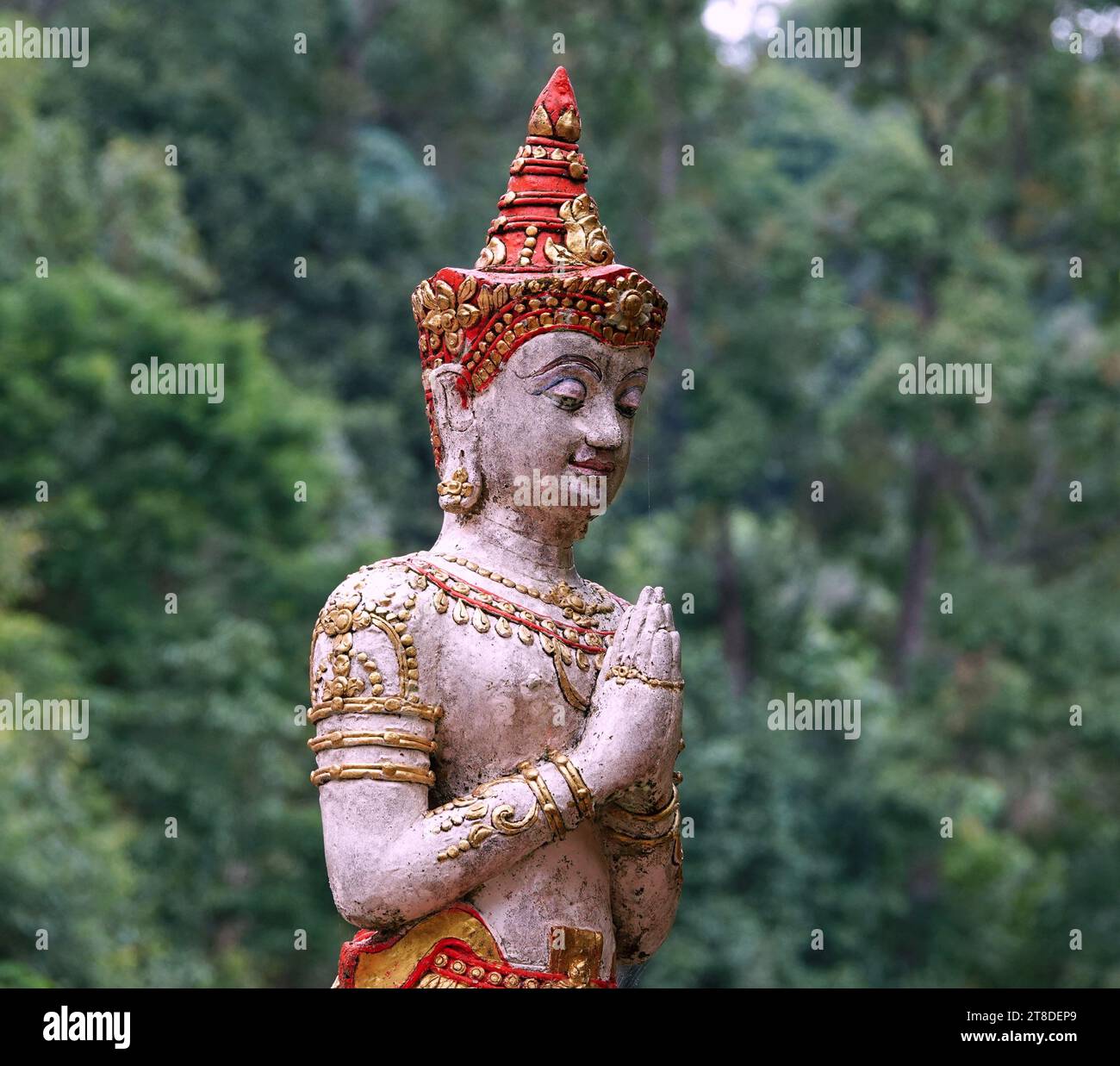 A serene Buddha statue stands in a peaceful woodland setting at Thai ...
