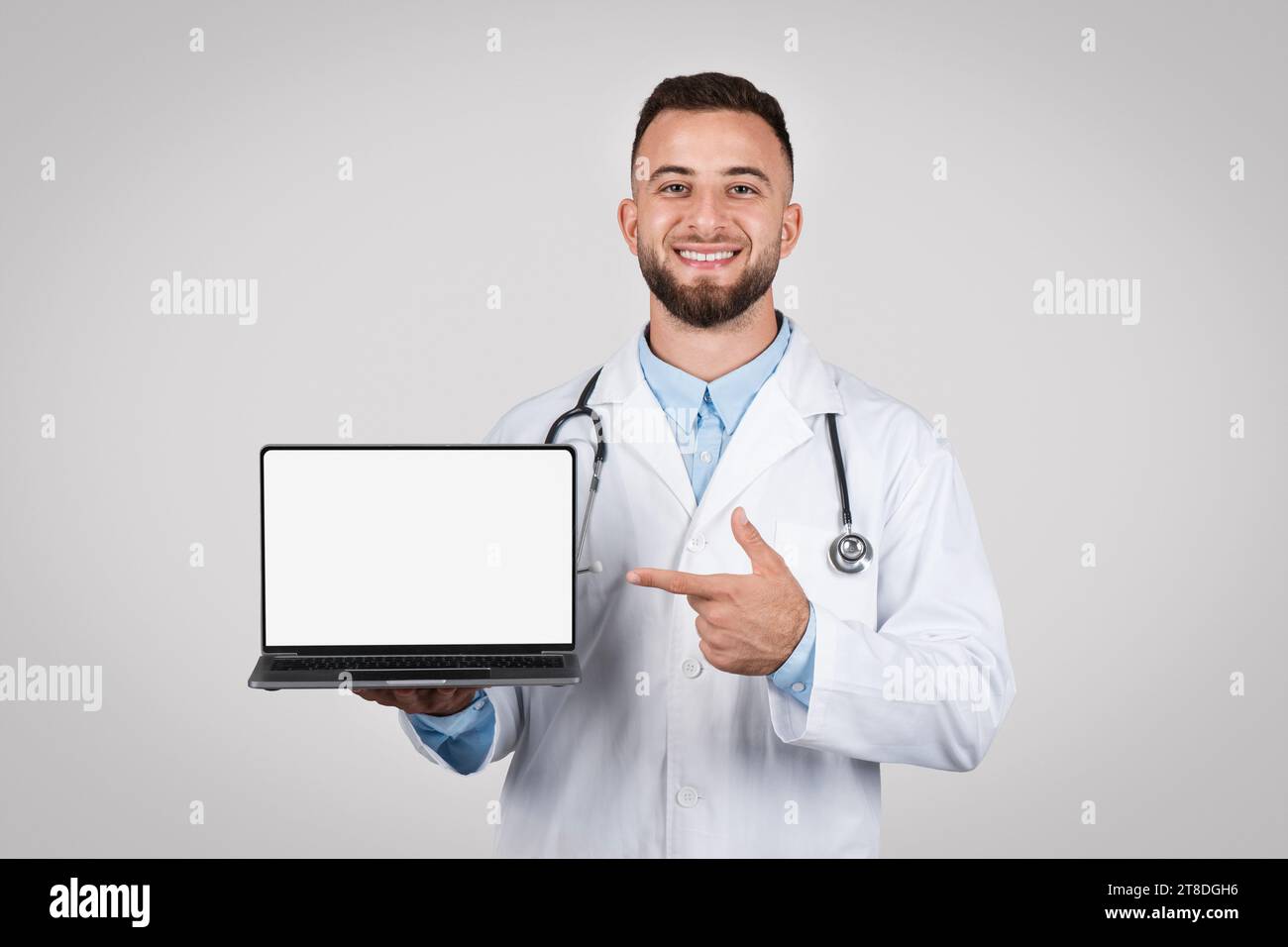Man doctor showing laptop screen, empty display Stock Photo - Alamy