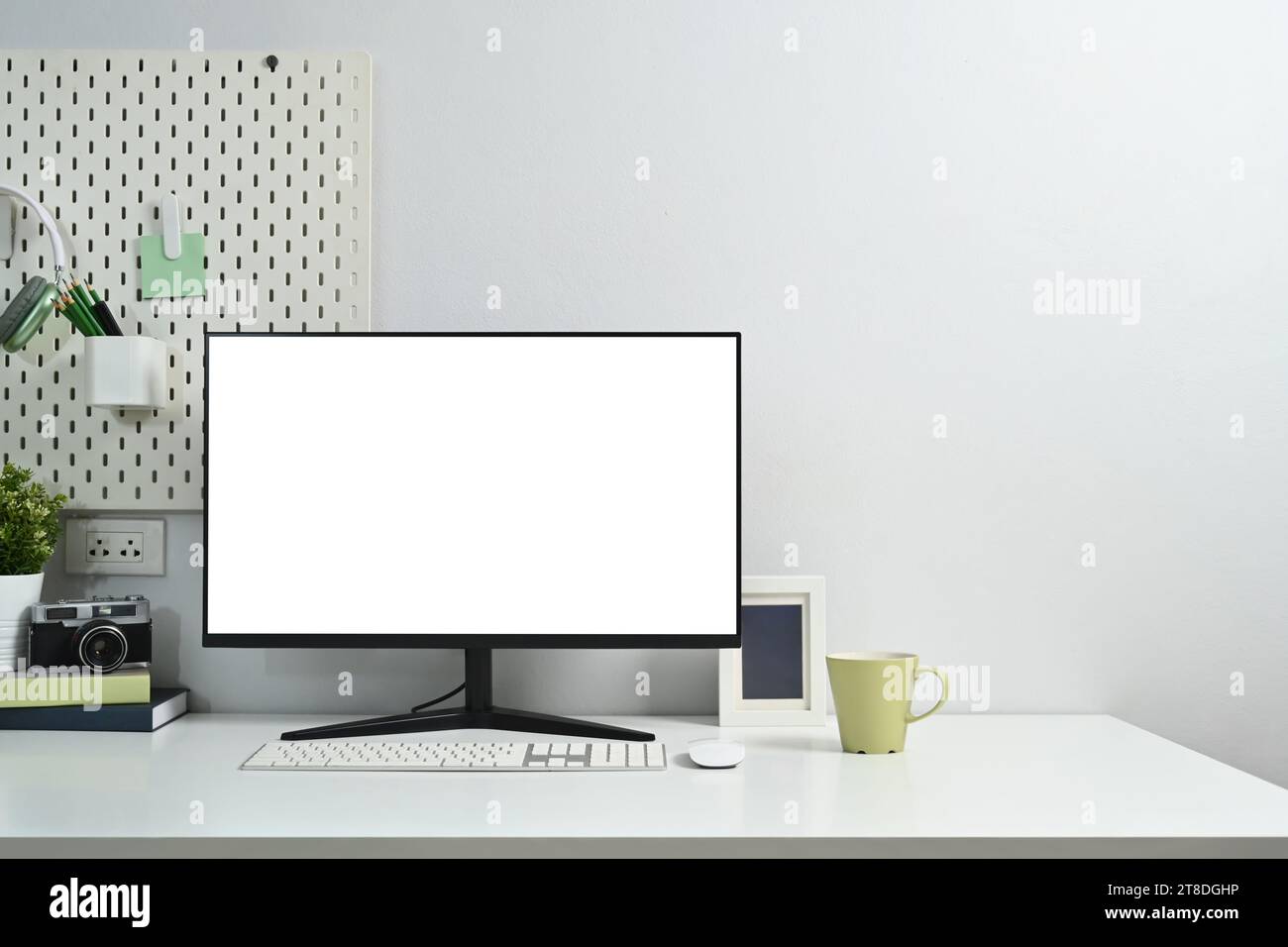 Front view computer monitor with blank screen, camera, books and ...