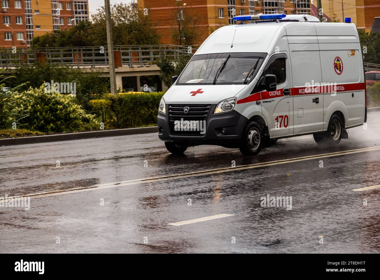 Ambulance drives down a city street during a rainy day Stock Photo - Alamy