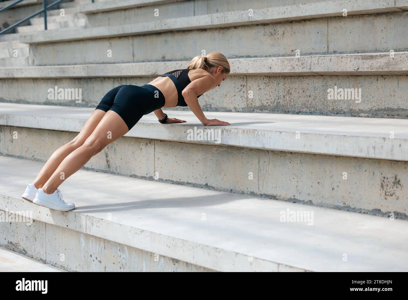 Blonde woman doing push ups on stairs outdoor Stock Photo - Alamy