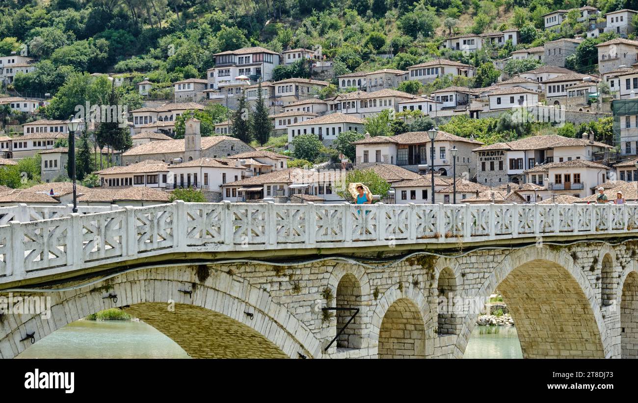 People walk across the Gorica Bridge across the River Osum in Berat ...