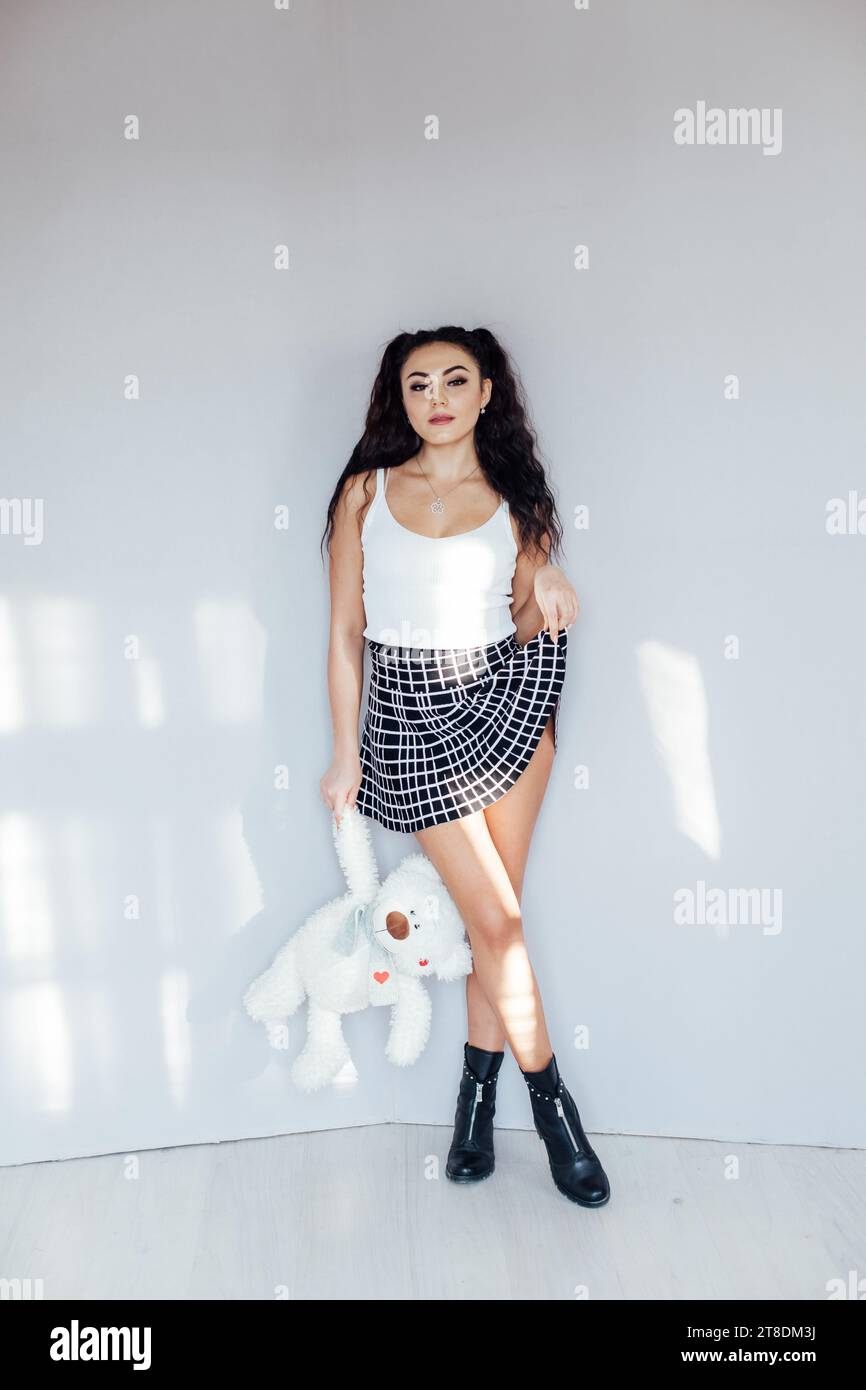 a schoolgirl with a soft toy poses on a light background Stock Photo ...
