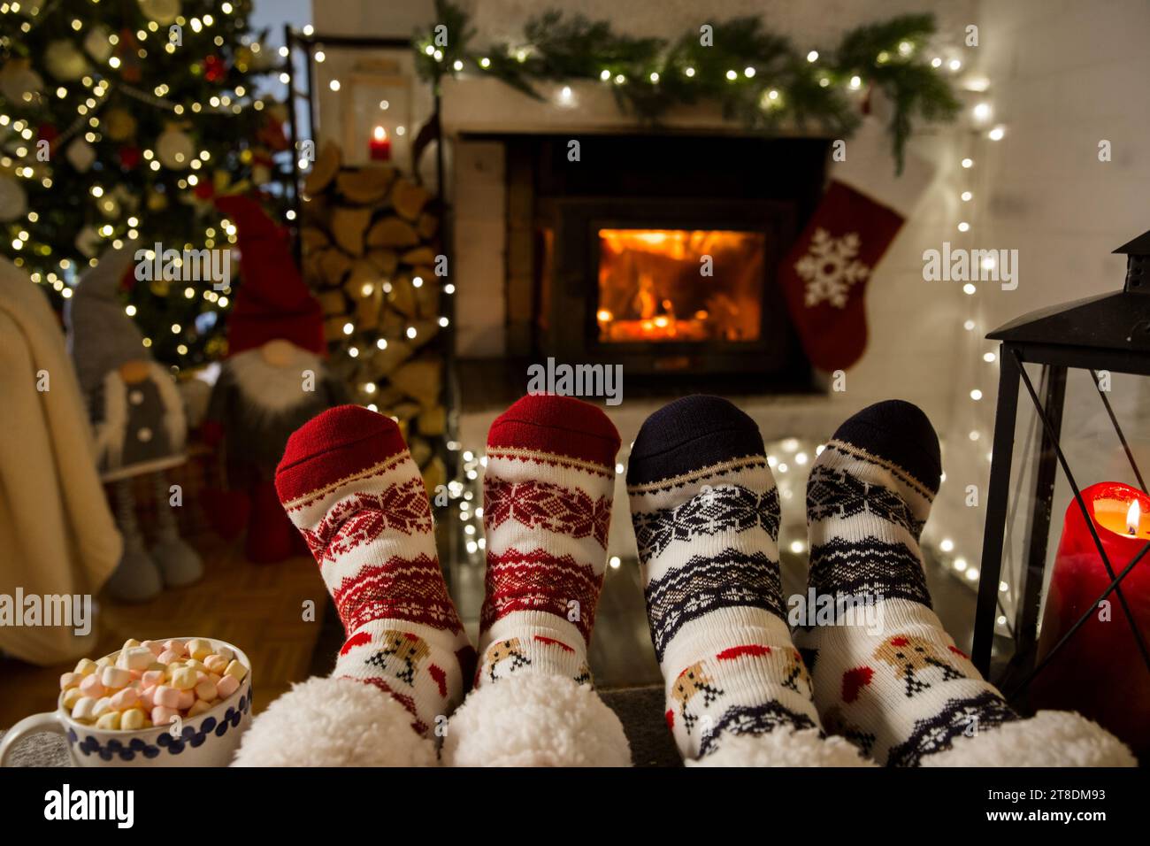 Couple enjoying by warm fireplace and warming up their feet in woolen ...