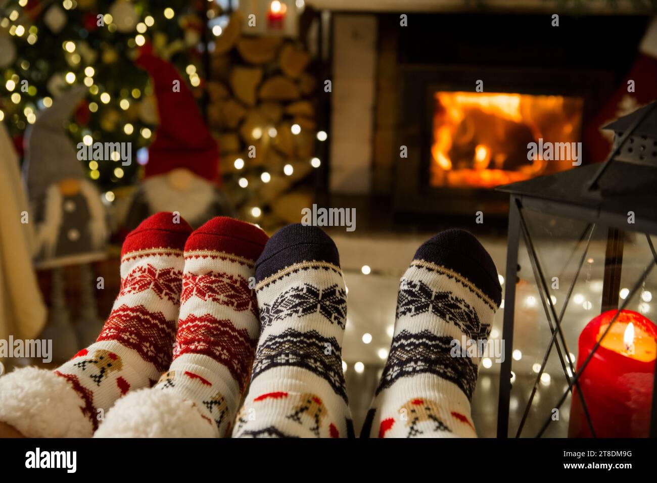 Couple enjoying by warm fireplace and warming up their feet in woolen ...