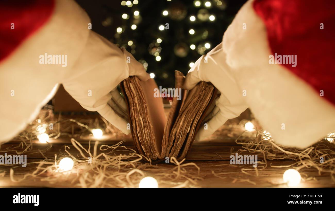 Santa Claus open a old book under tree Stock Photo - Alamy