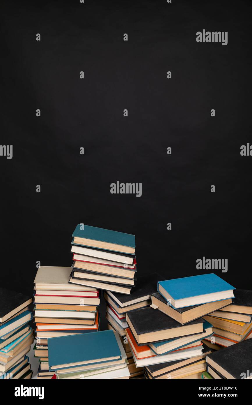 a stack of books for studying in the university library on a black ...