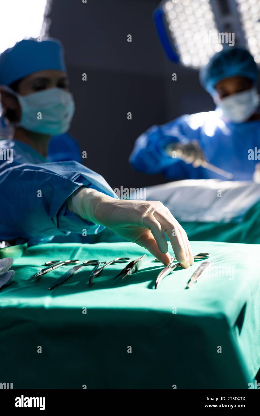 Diverse female doctors with face masks doing surgery in hospital ...