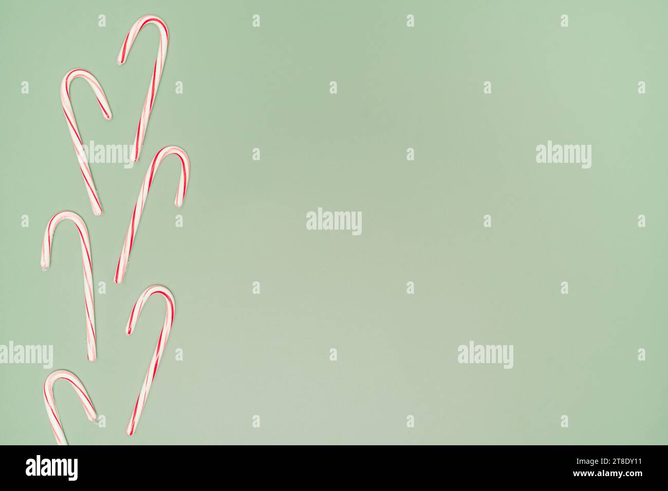 Two Lines of Candy Canes on a Green Background with Copy on the Right ...