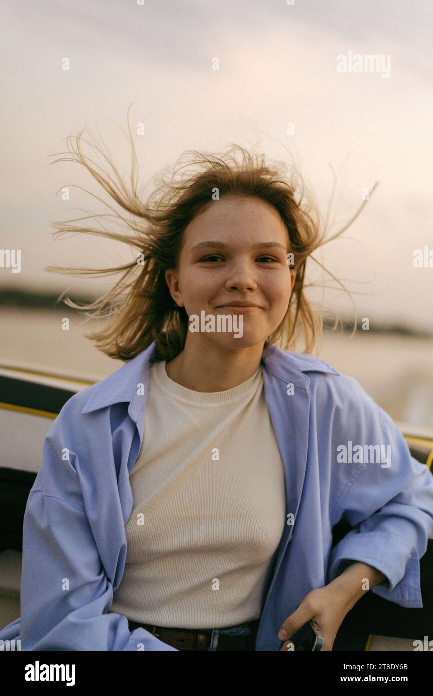 Young beautiful woman rides a speedboat on the lake. Wind in hair Stock ...