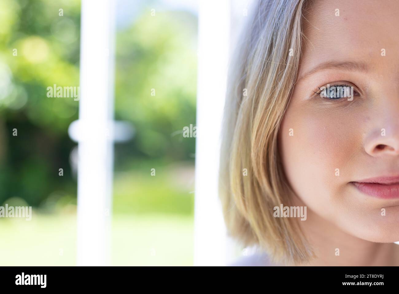 Portrait of happy caucasian female teenager leaning on window sill over ...