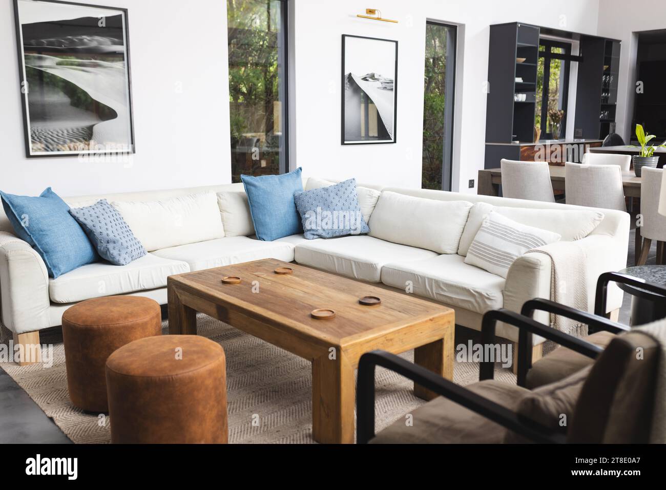 Big empty living room with wooden table, big white couch and pictures ...