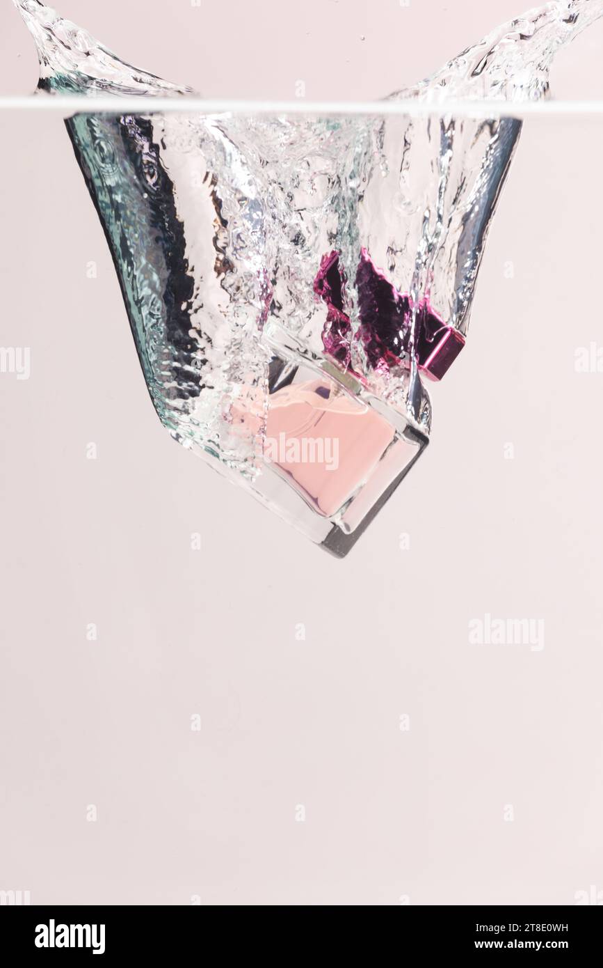 Vertical image of beauty product perfume bottle falling into water ...