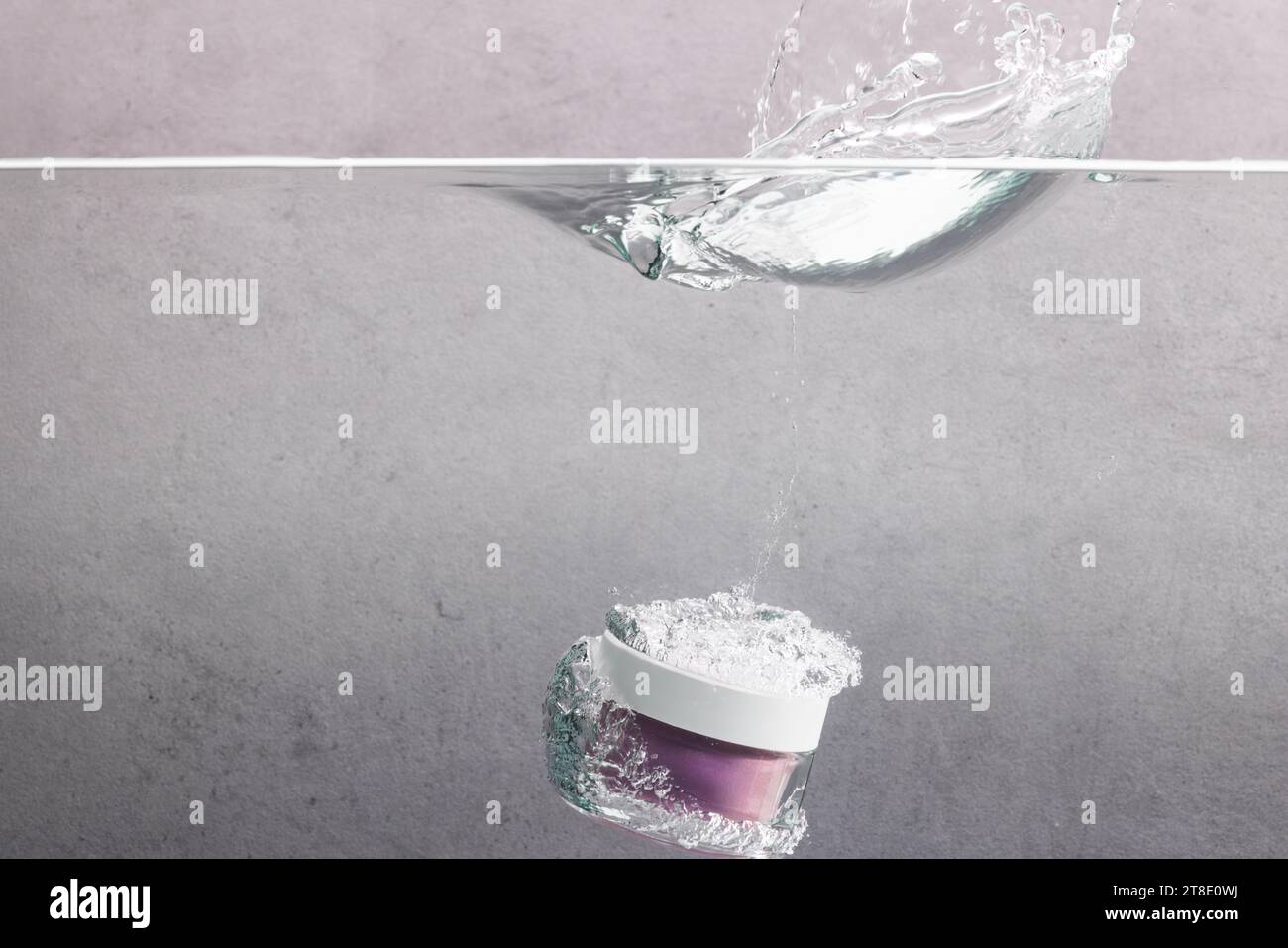 Beauty product tub falling into water with copy space background on ...