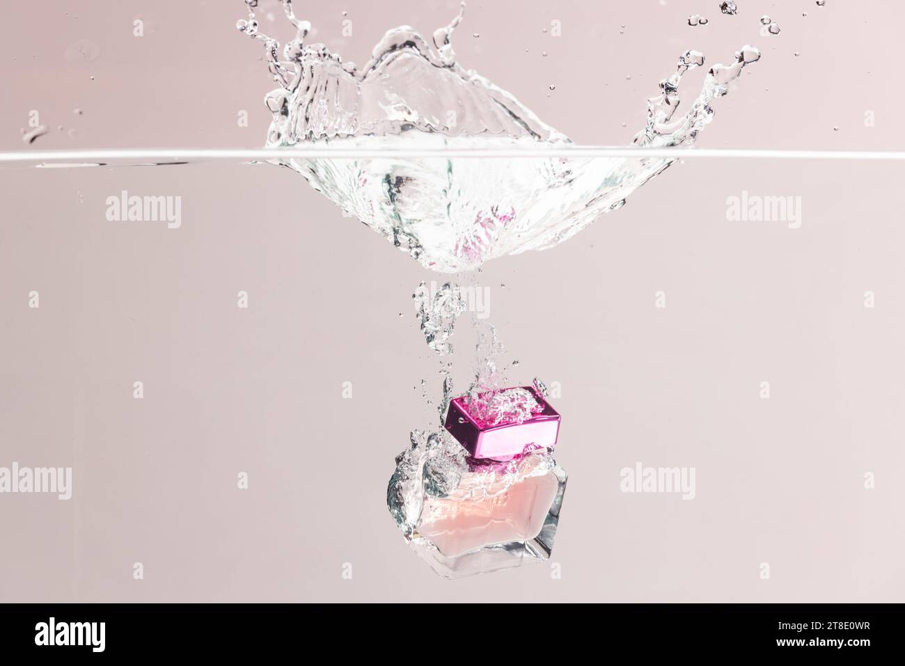 Beauty product perfume bottle falling into water with copy space ...