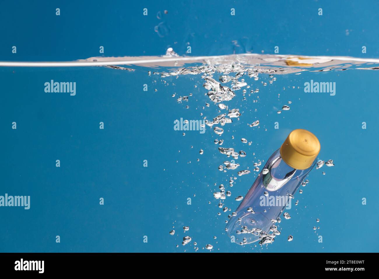 Beauty product bottle falling into water with copy space background on ...