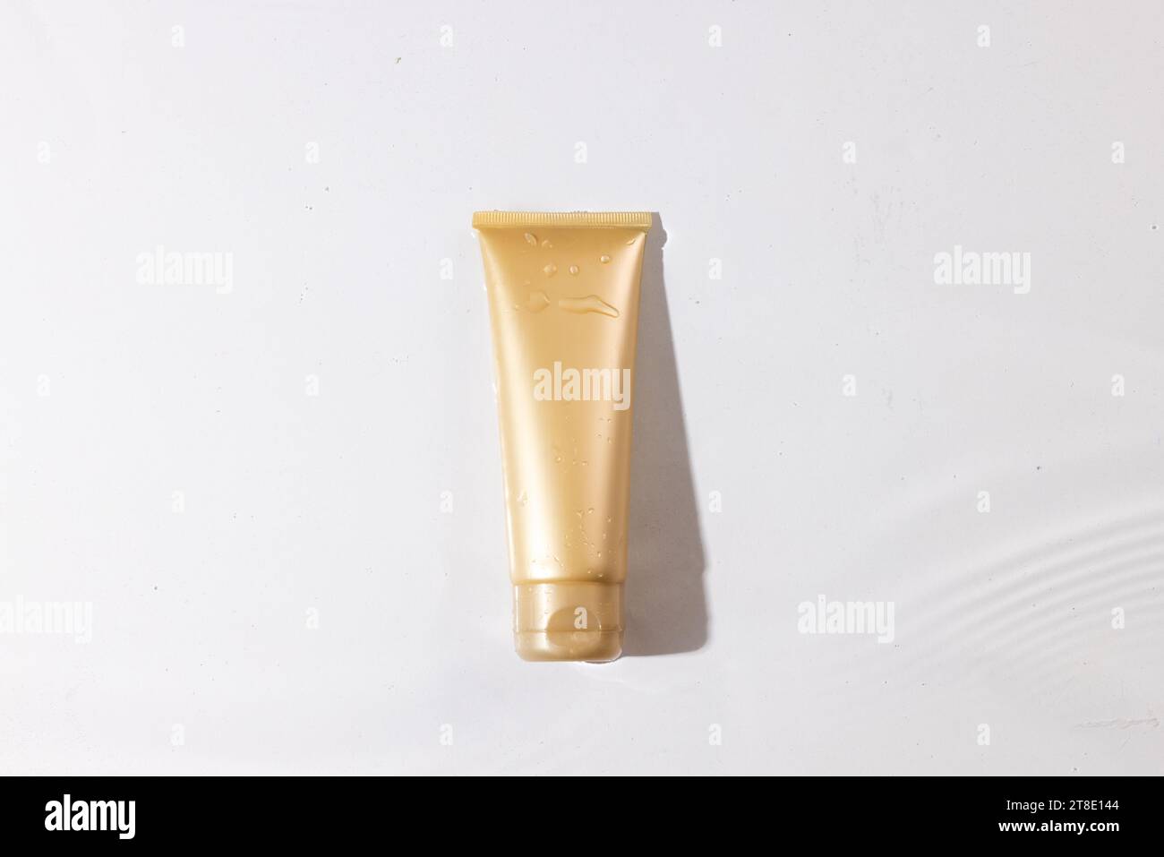 Beauty product tube in water with copy space background on white ...
