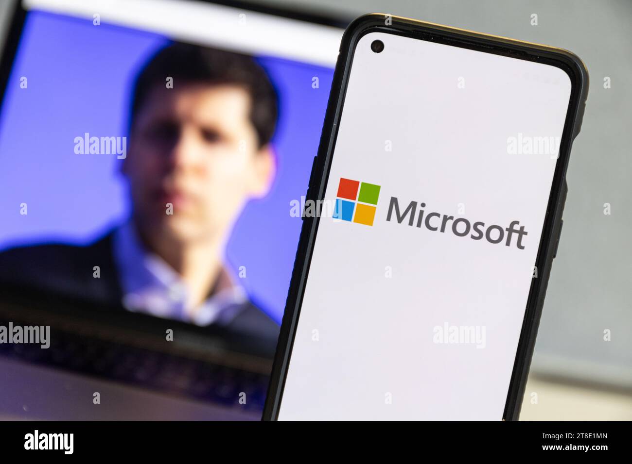 Microsoft logo and Sam Altman in background on screen.Microsoft hires ...