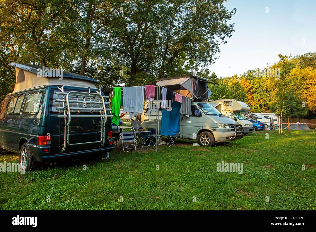 life camping with motorhomes and cars and tents in the early morning ...