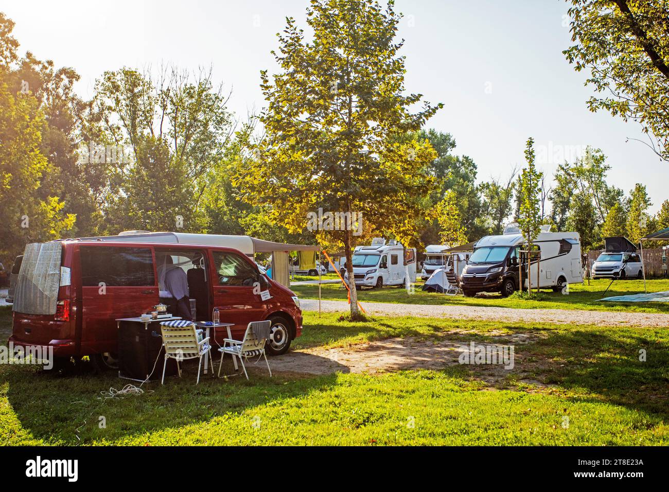 camping with motorhomes and cars and tents in the early morning. travel ...
