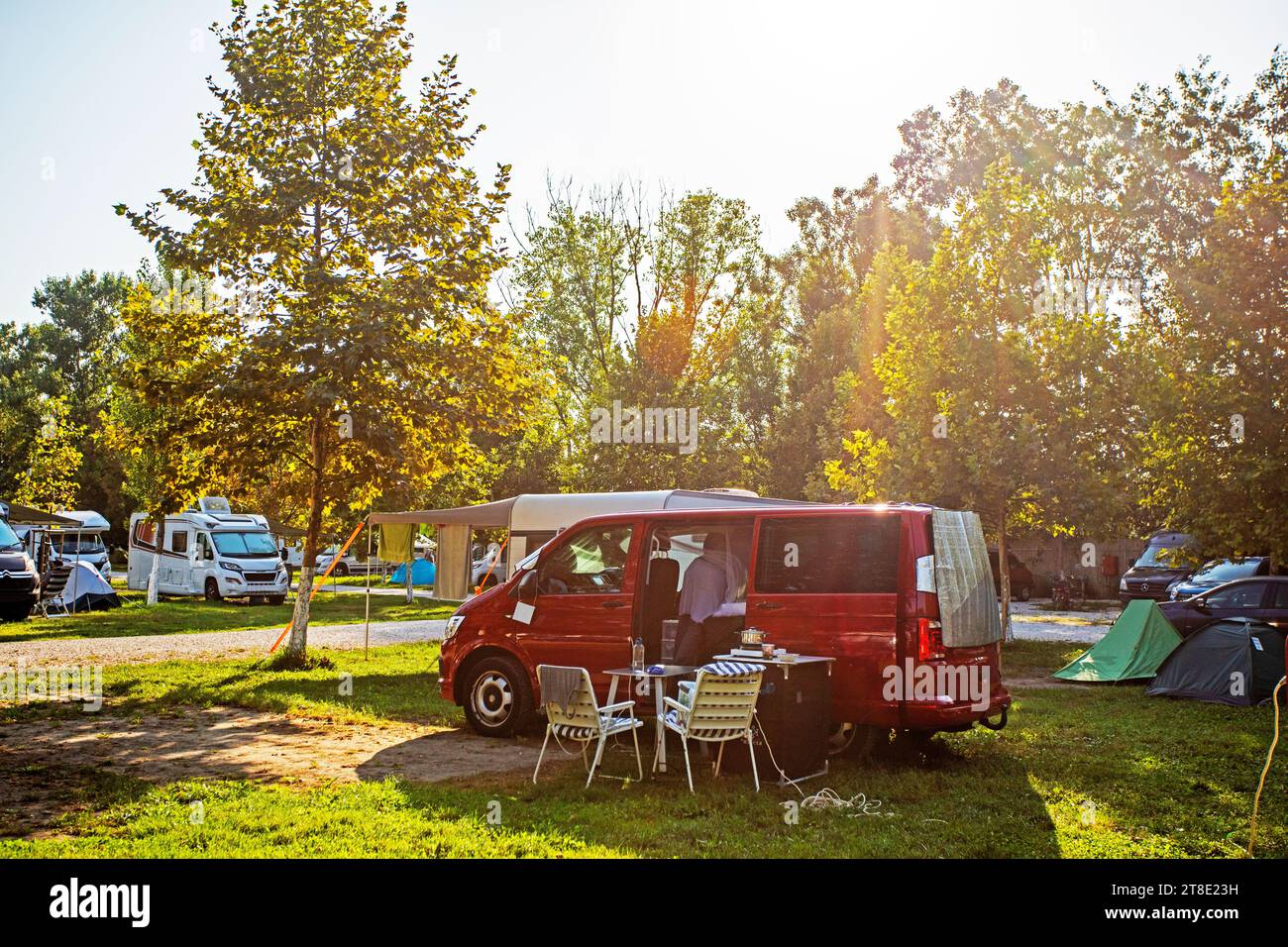 camping with motorhomes and cars and tents in the early morning. travel ...