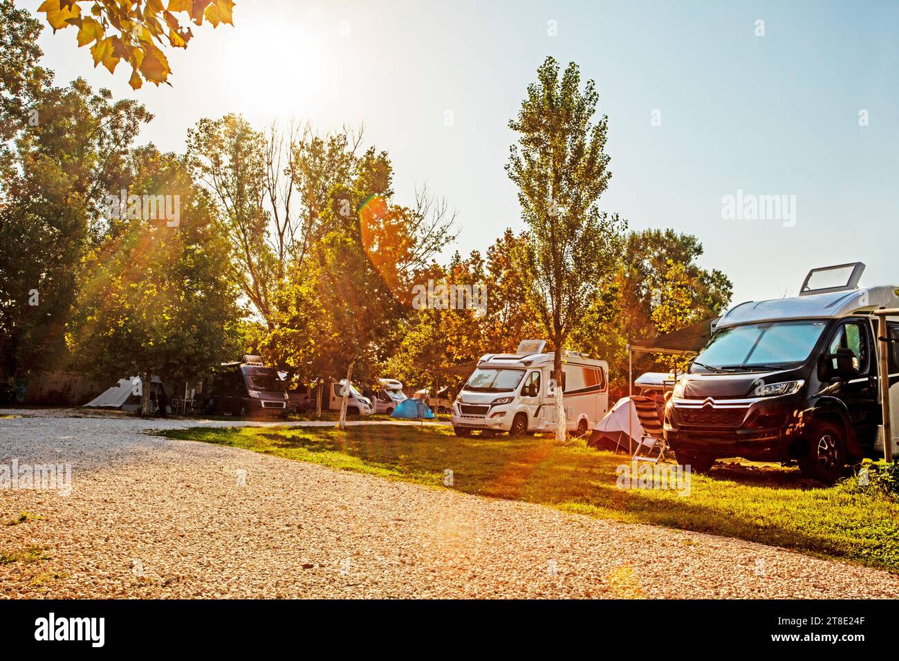 camping life with motorhomes and cars and tents in the early morning ...