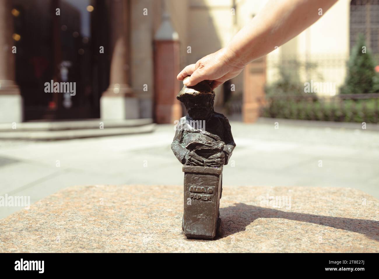 Woman touching a small dwarf statue on the market square in Wroclaw ...