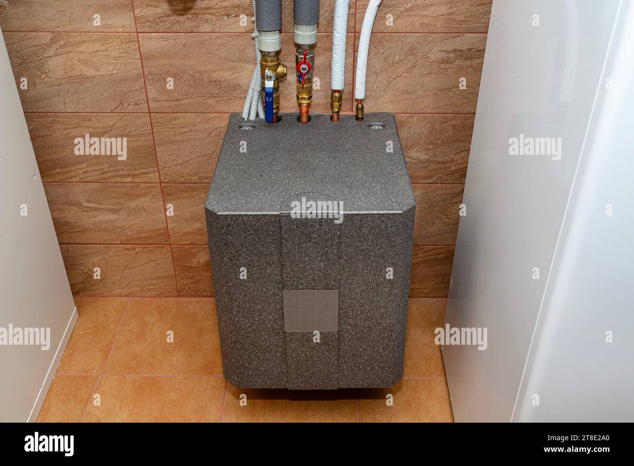 A modern air heat pump installed in the home's boiler room, visible ...