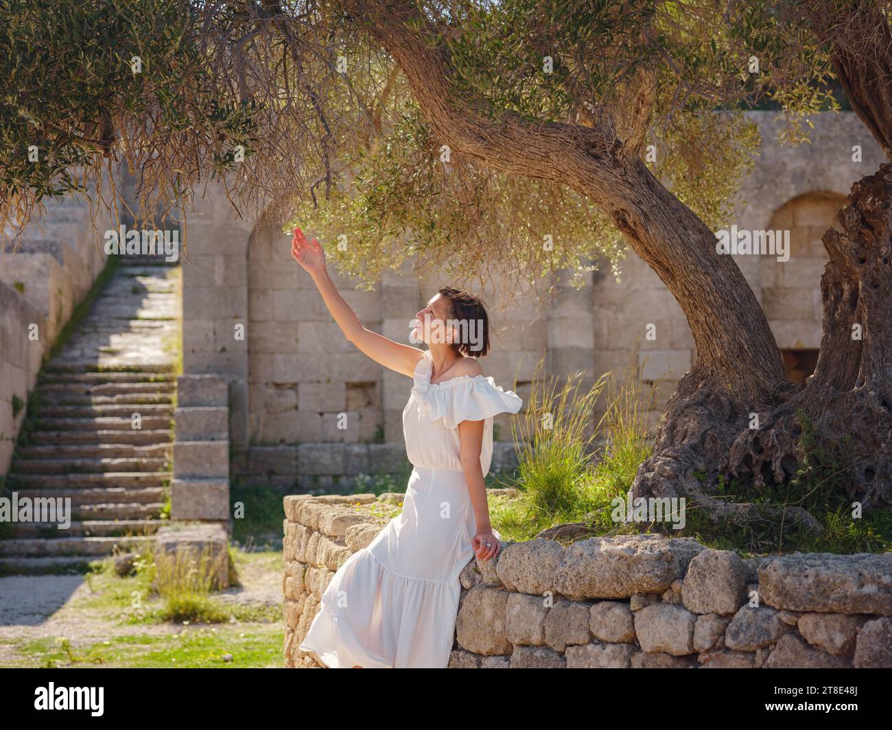 Beautiful Asian young woman in white dress outdoor. Acropolis of Rhodes ...