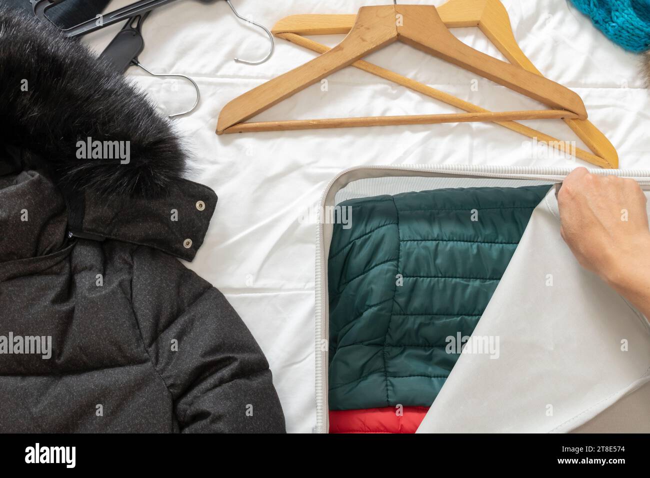 Horizontal photo, woman's hand closing the zipper of a cloth box, with ...