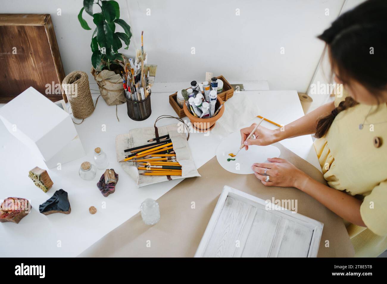 She is in the creative process, selecting a shade of color on the ...