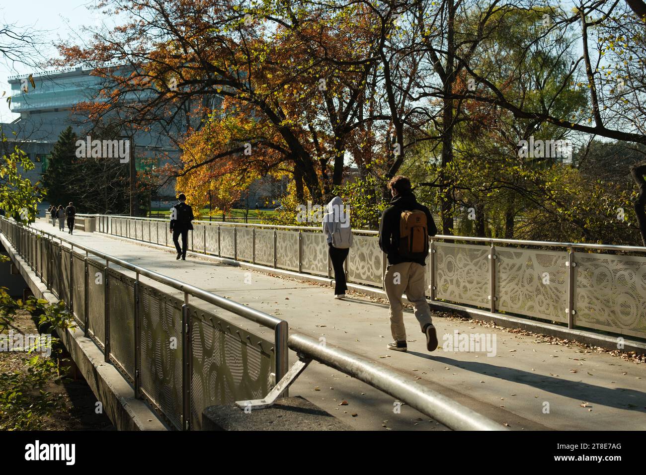 Michigan Statue University students walking across a bridge over the ...