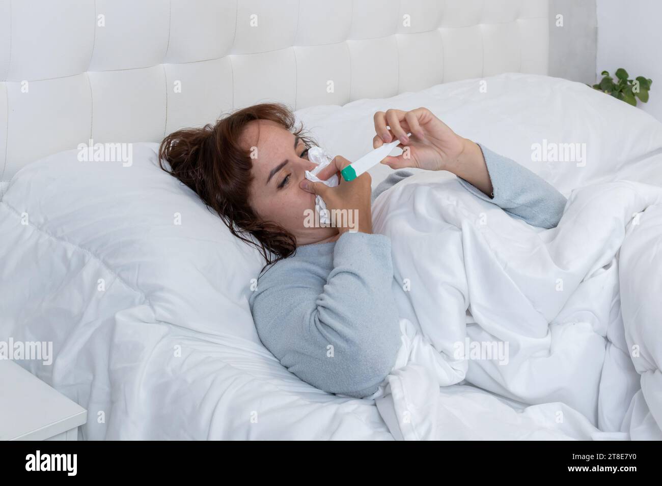 Horizontal photo of a mid adult Caucasian woman, sick, with a cold ...