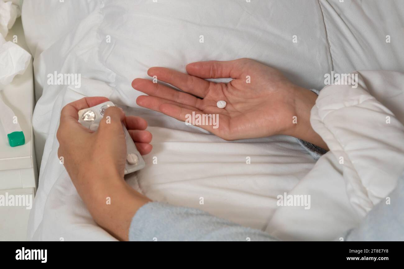Horizontal photo of a sick Caucasian mid adult woman wearing long blue ...