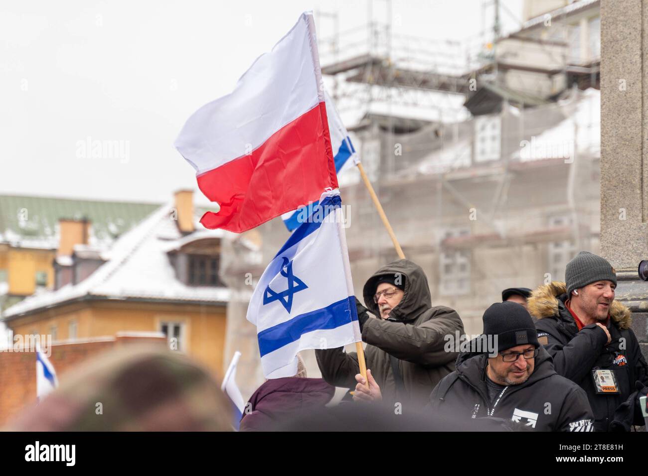 A demonstrator waves the national flags of Israel and Poland while ...