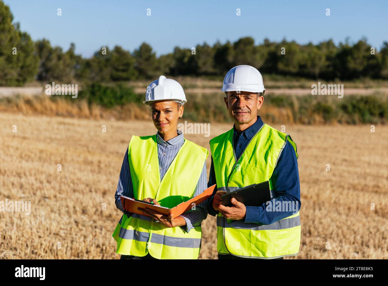 Engineers in work clothes stand on a sunny day in a rural field Stock ...