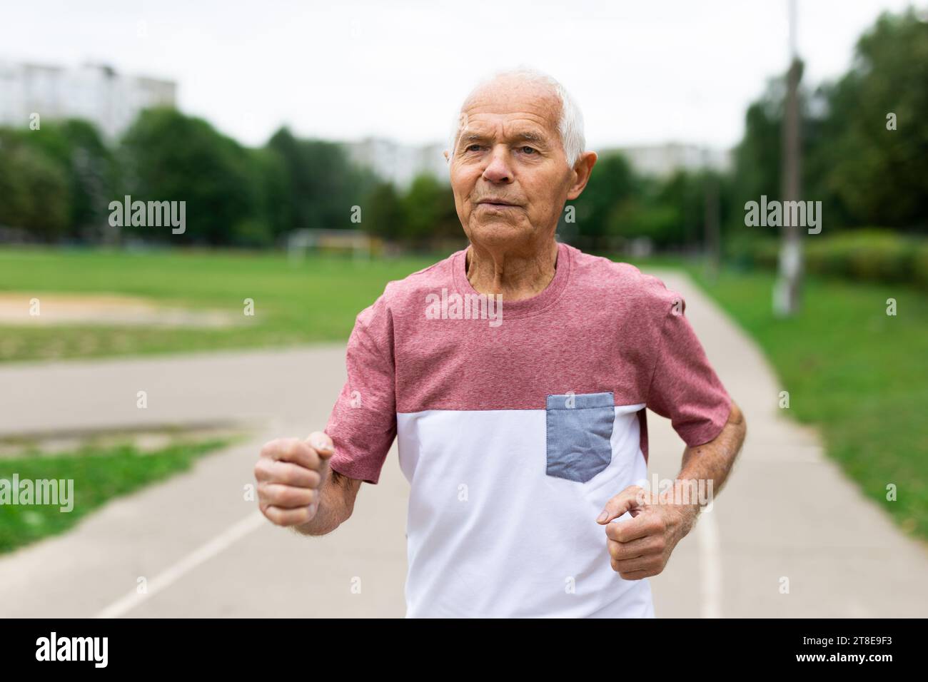 Elderly man running on walkway Stock Photo - Alamy