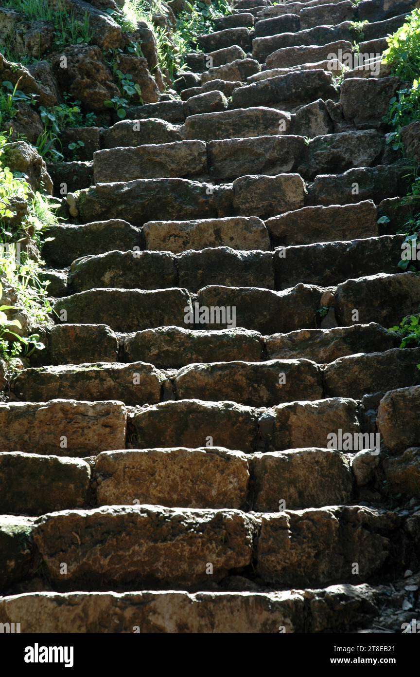 An old staircase built from stones and splashed with sunlight skimming ...