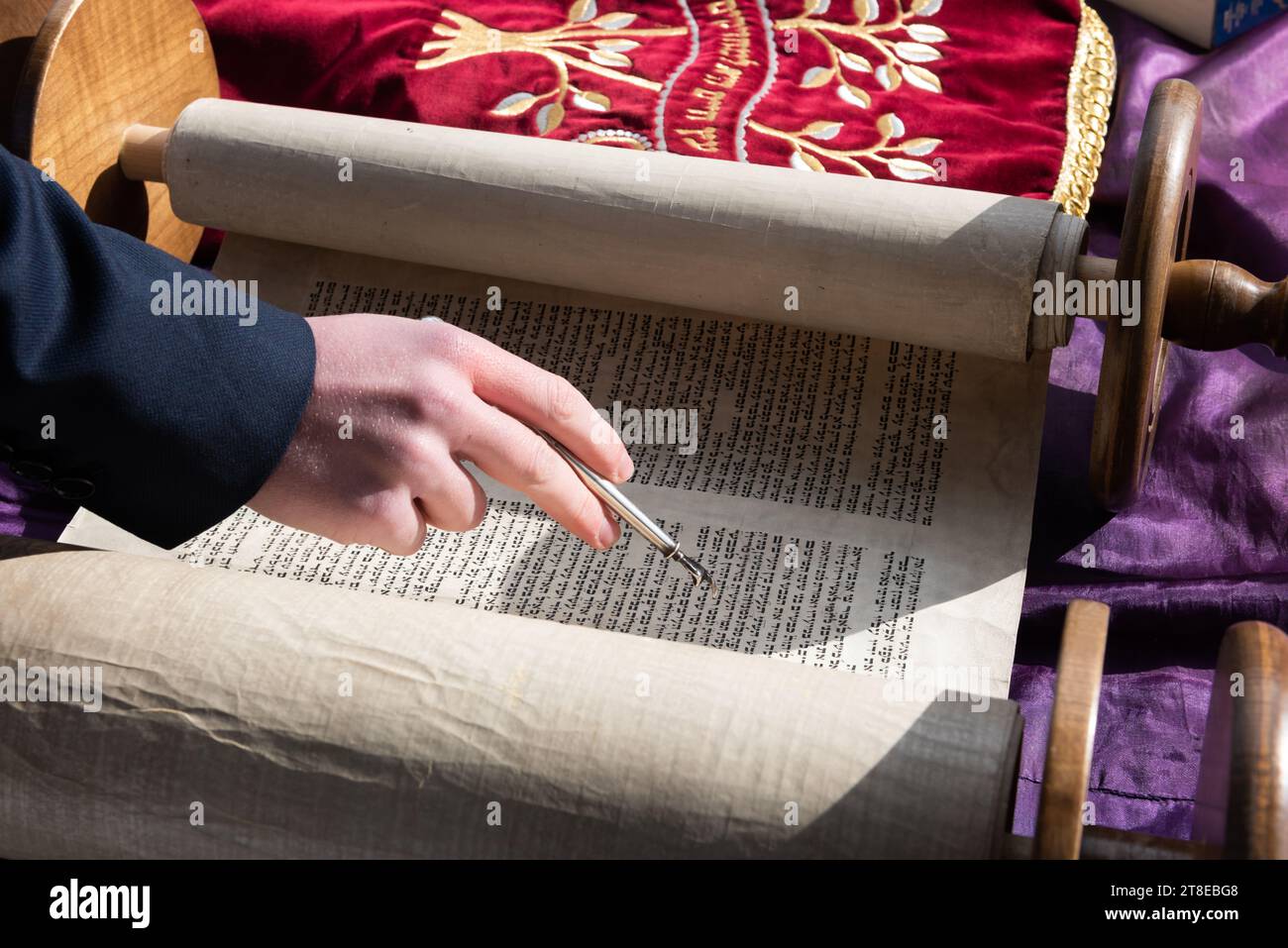 Closeup of a hand holding a yad or pointer during the reading of the ...