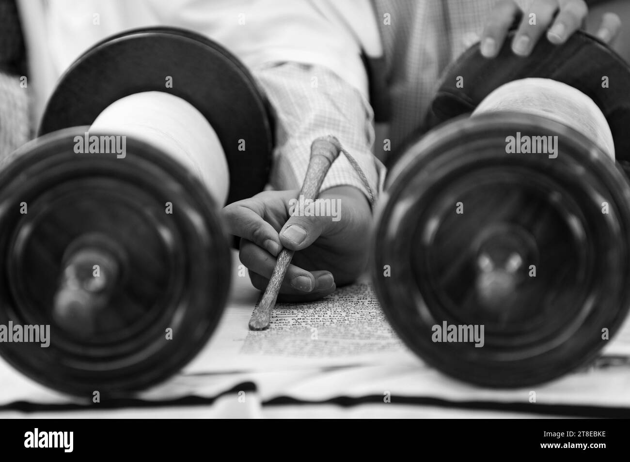 Detailed closeup of a man's hand hold a yad or pointer while reading ...