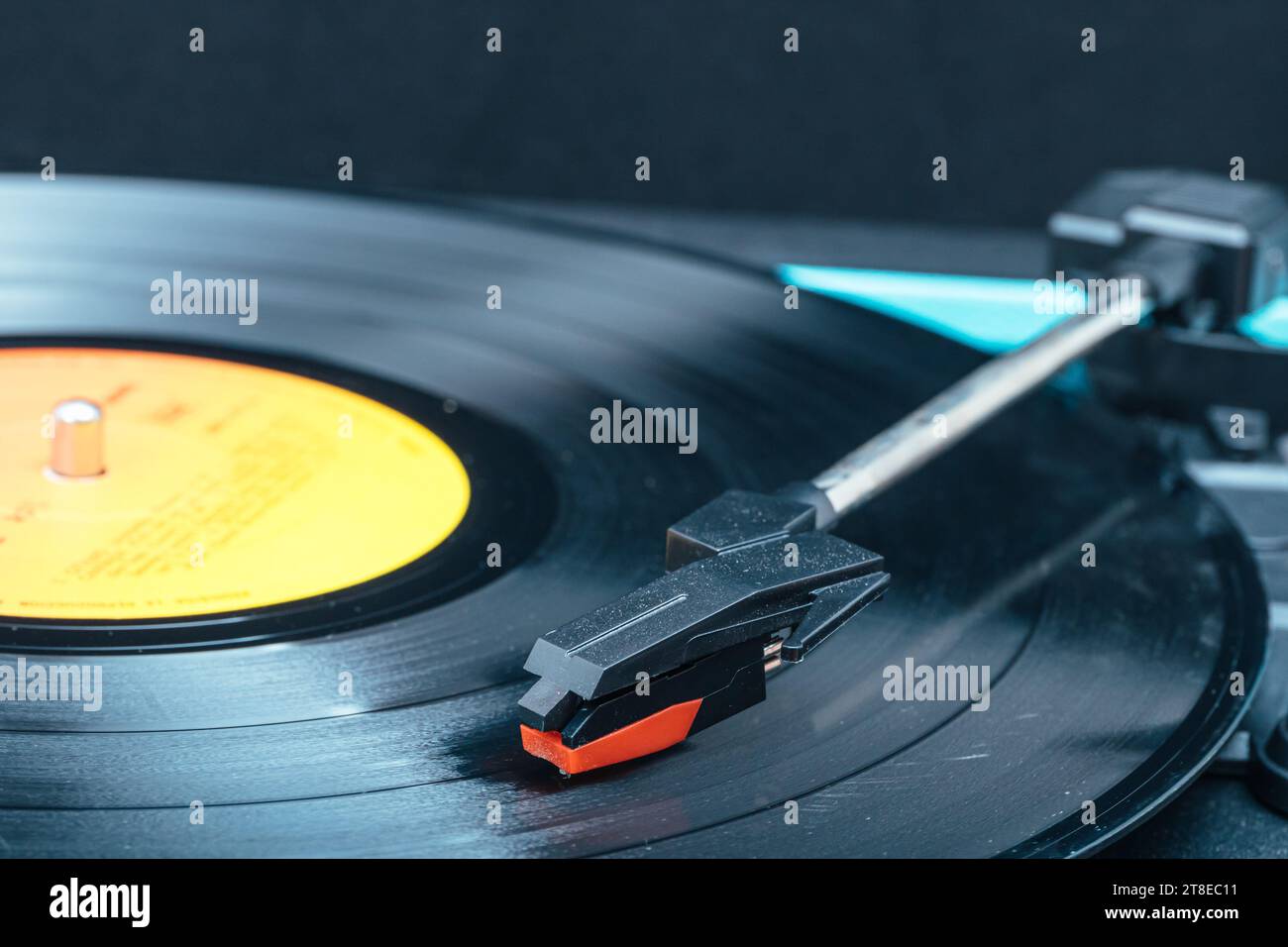 Extreme close up horizontal photo of a vinyl on a blue turntable. Copy ...