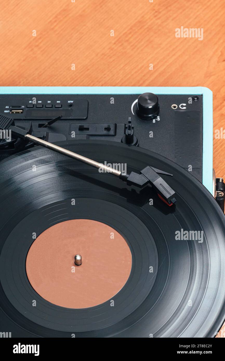 Vertical photo of a blue record player, on wooden table. Concept ...