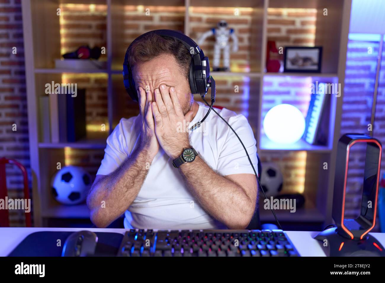 Middle age man with beard playing video games wearing headphones with ...