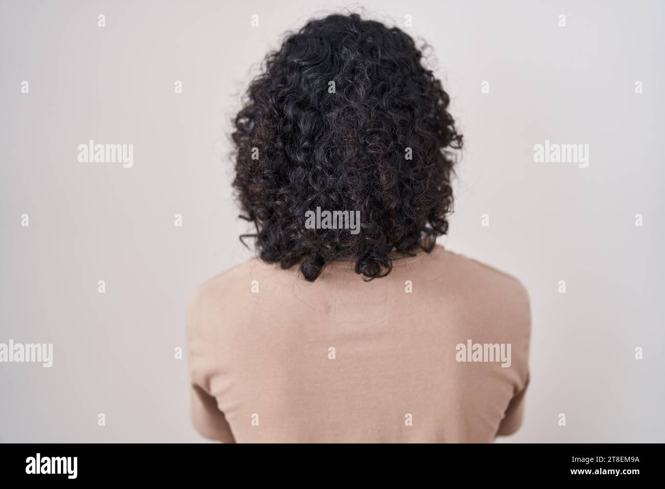 Hispanic man with curly hair standing over white background standing ...